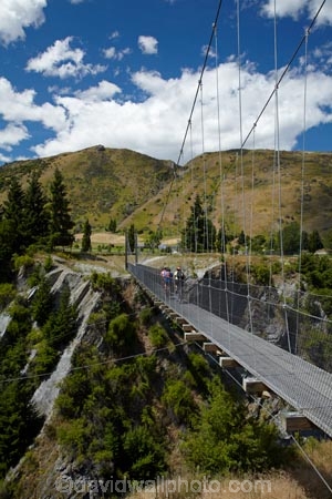 Mountain bikers high above the Arrow River on Edgar suspension bridge ...
